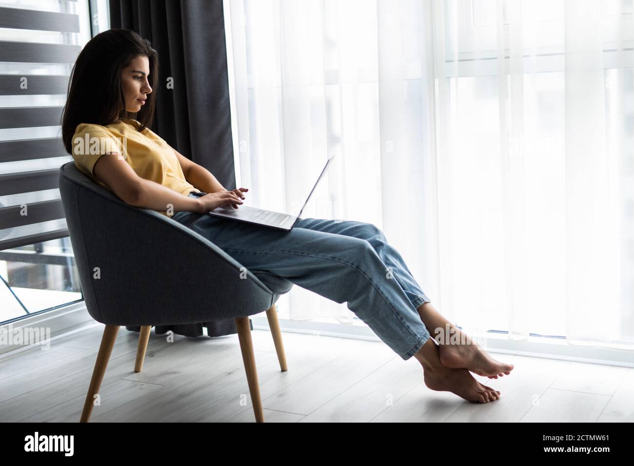 Young woman sitting side profile chair hi-res stock photography and ...