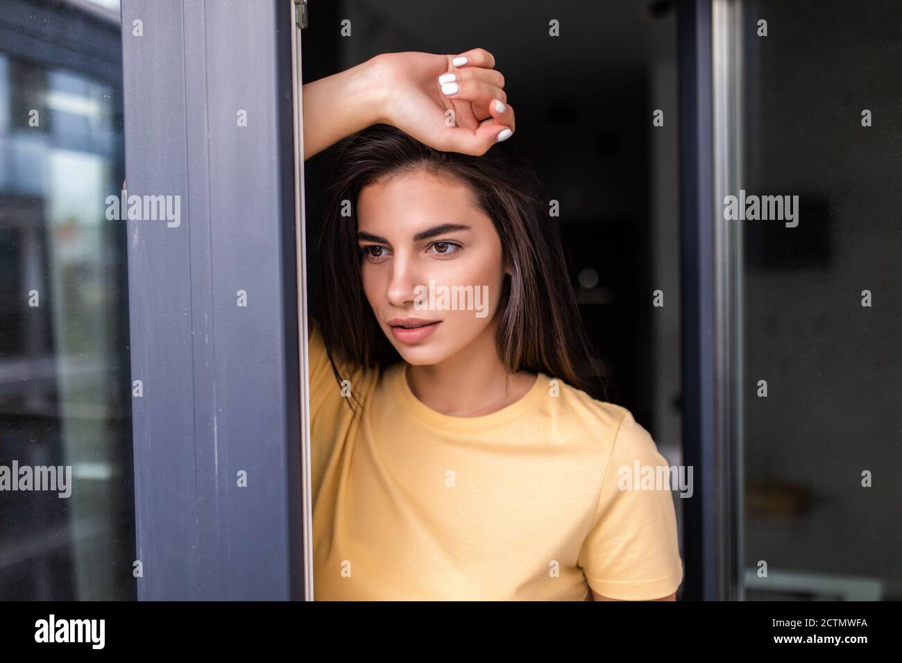 Young woman opening window in living room Stock Photo - Alamy