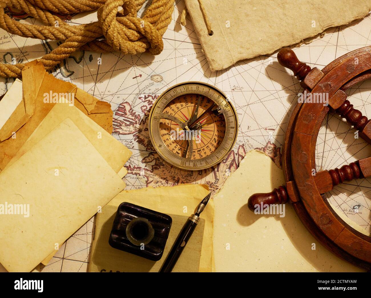 Compass, letters and ships's wheel over old map from XVIII century ...