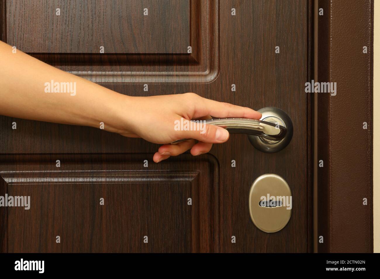 Young woman hand hold wooden door handle Stock Photo - Alamy