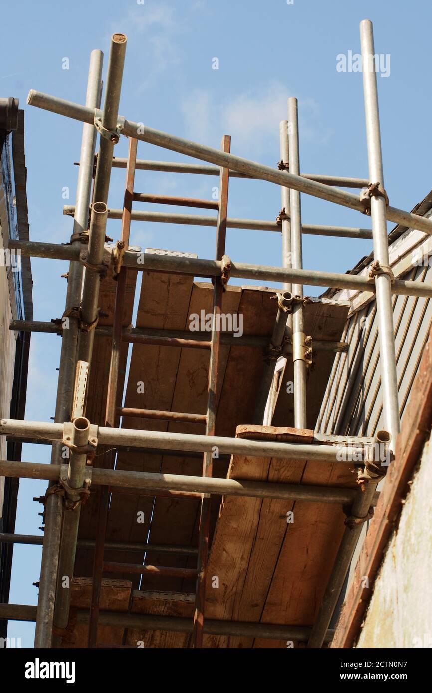 A view looking up from the ground to scaffolding in between two houses ...