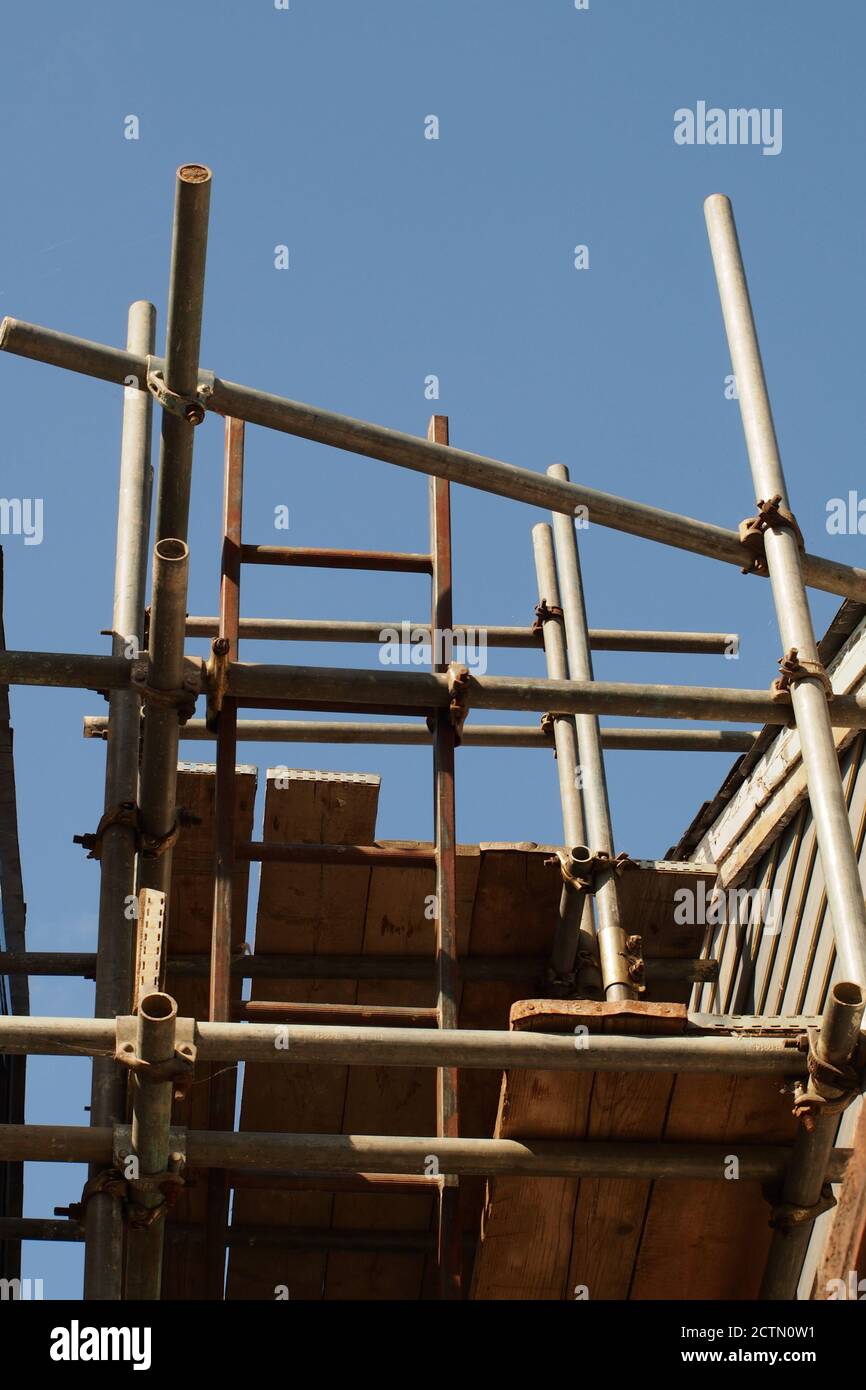 A view looking up from the ground to scaffolding in between two houses ...