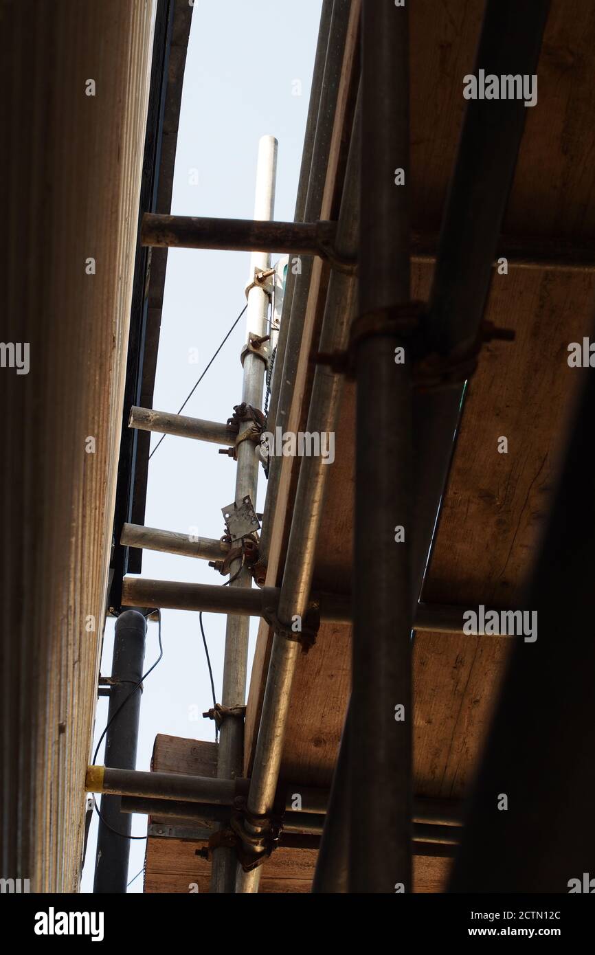 A view looking up under scaffolding boards and at scaffolding couplers ...