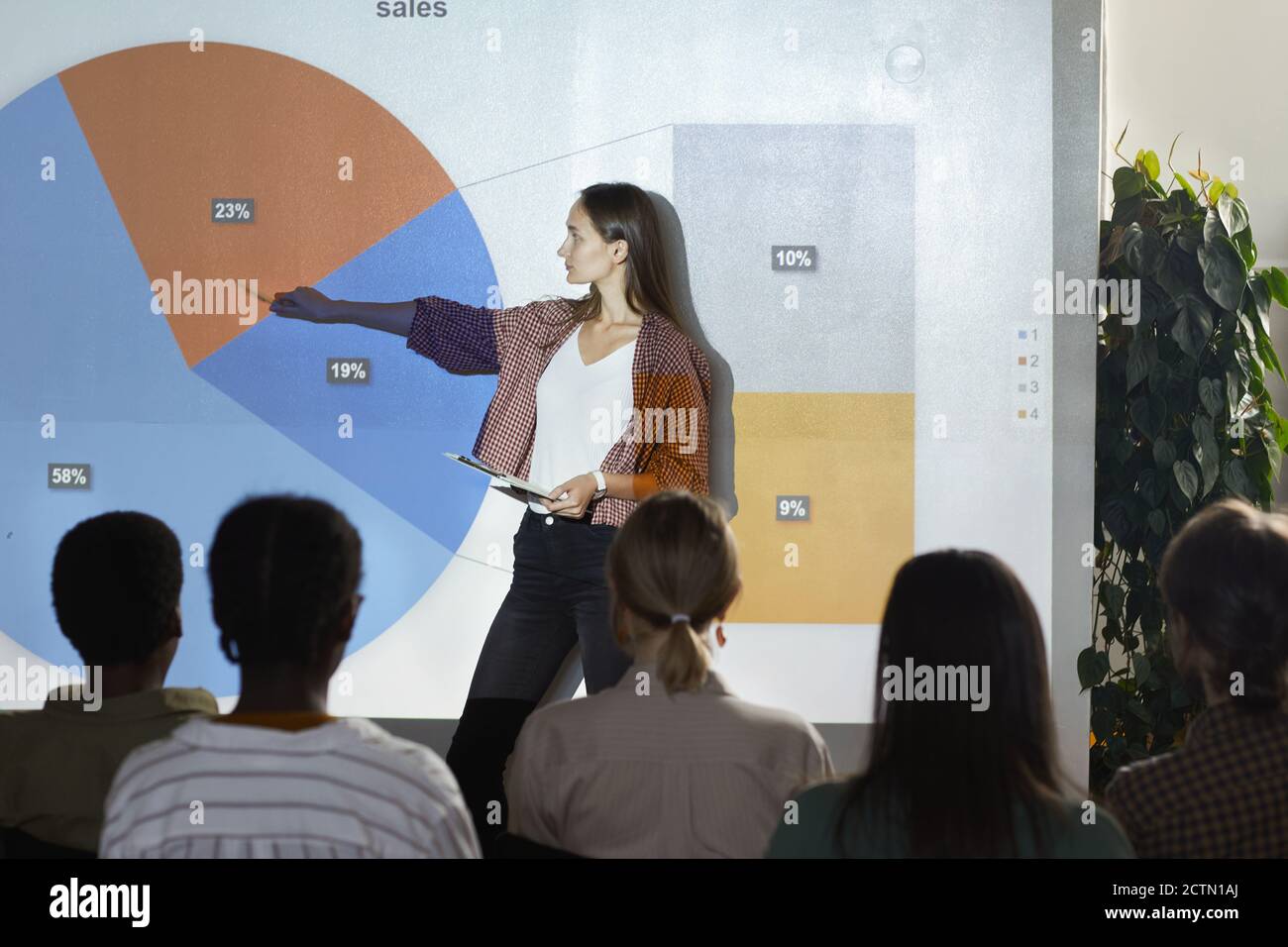 Side view portrait of young woman pointing at data chart with ...