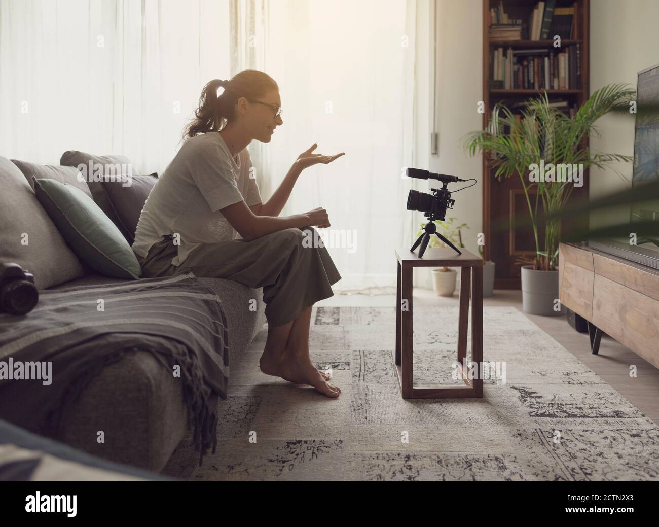 Professional youtuber and vlogger sitting on the couch at home and ...