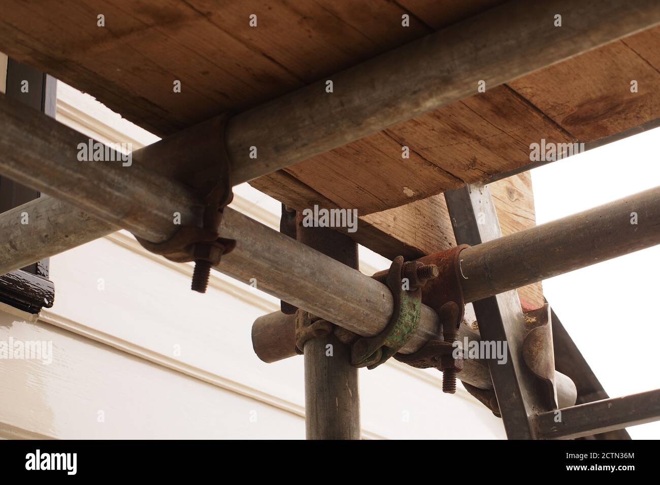 A view looking up under scaffolding boards and at scaffolding couplers ...