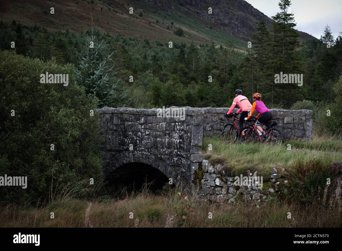Brightly dressed cyclists enjoying gravel cycling in Galloway Forest ...