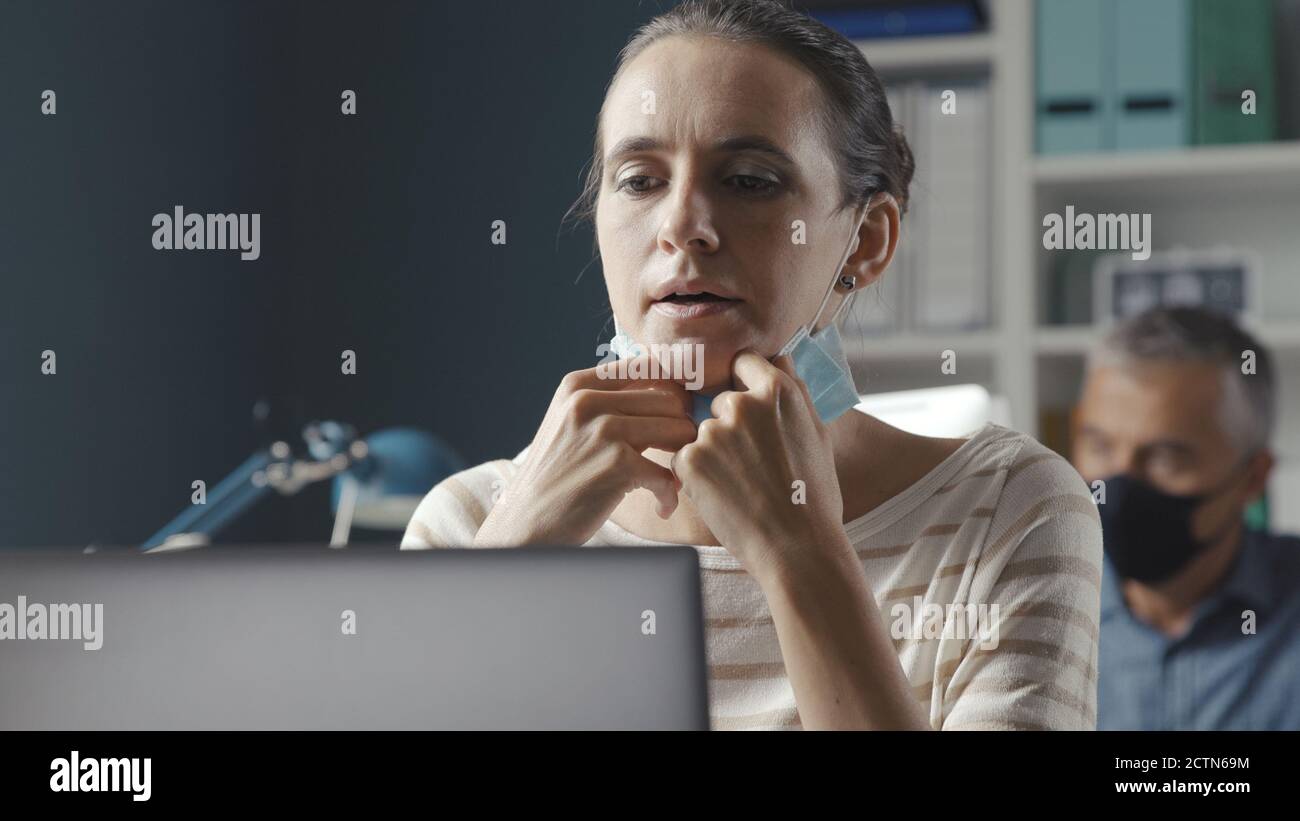 Woman working in the office and having difficulties breathing with face ...