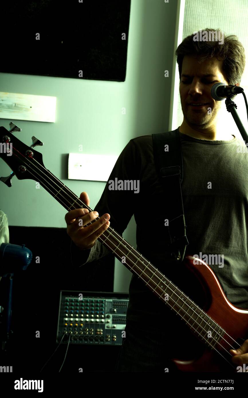 A Rock singer playing bass in the rehearsal Studio Stock Photo - Alamy