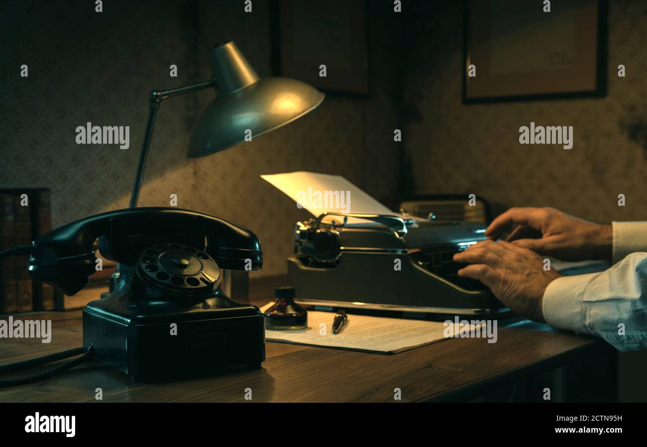 Film noir journalist working at office desk in the office, he is typing ...