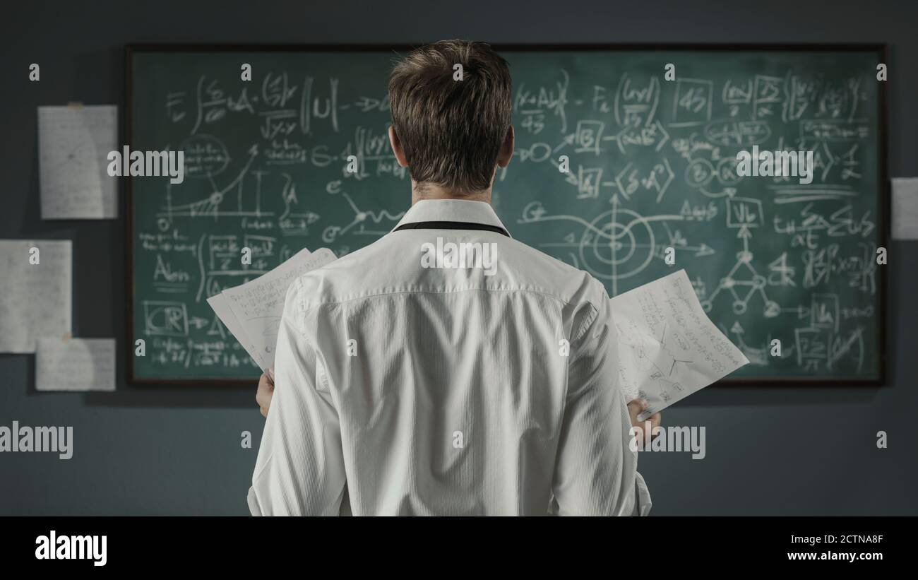 Young mathematician and researcher studying maths formulas on the ...