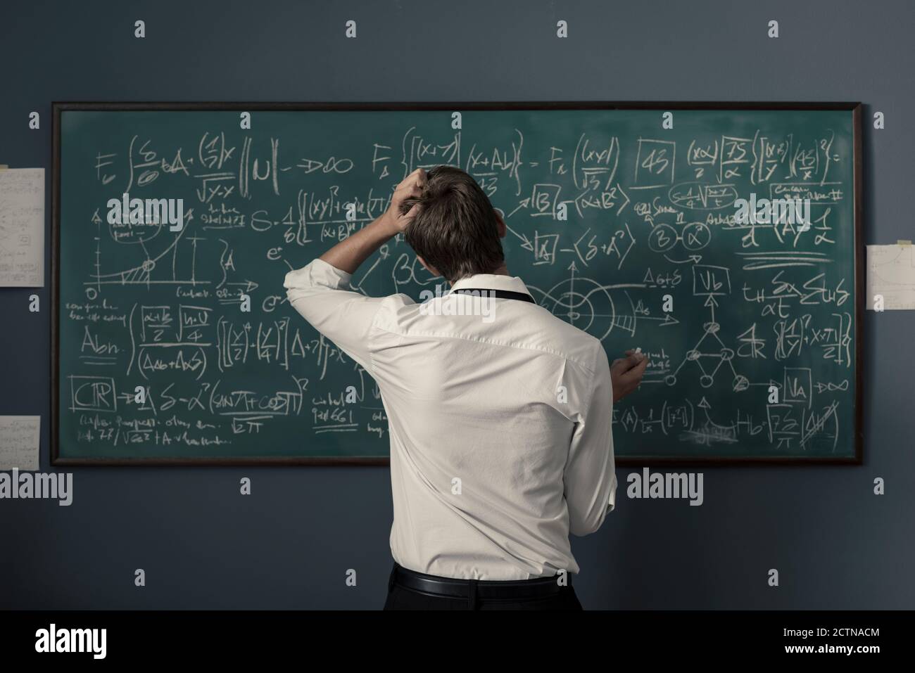 Young mathematician solving problems and writing formulas on the ...