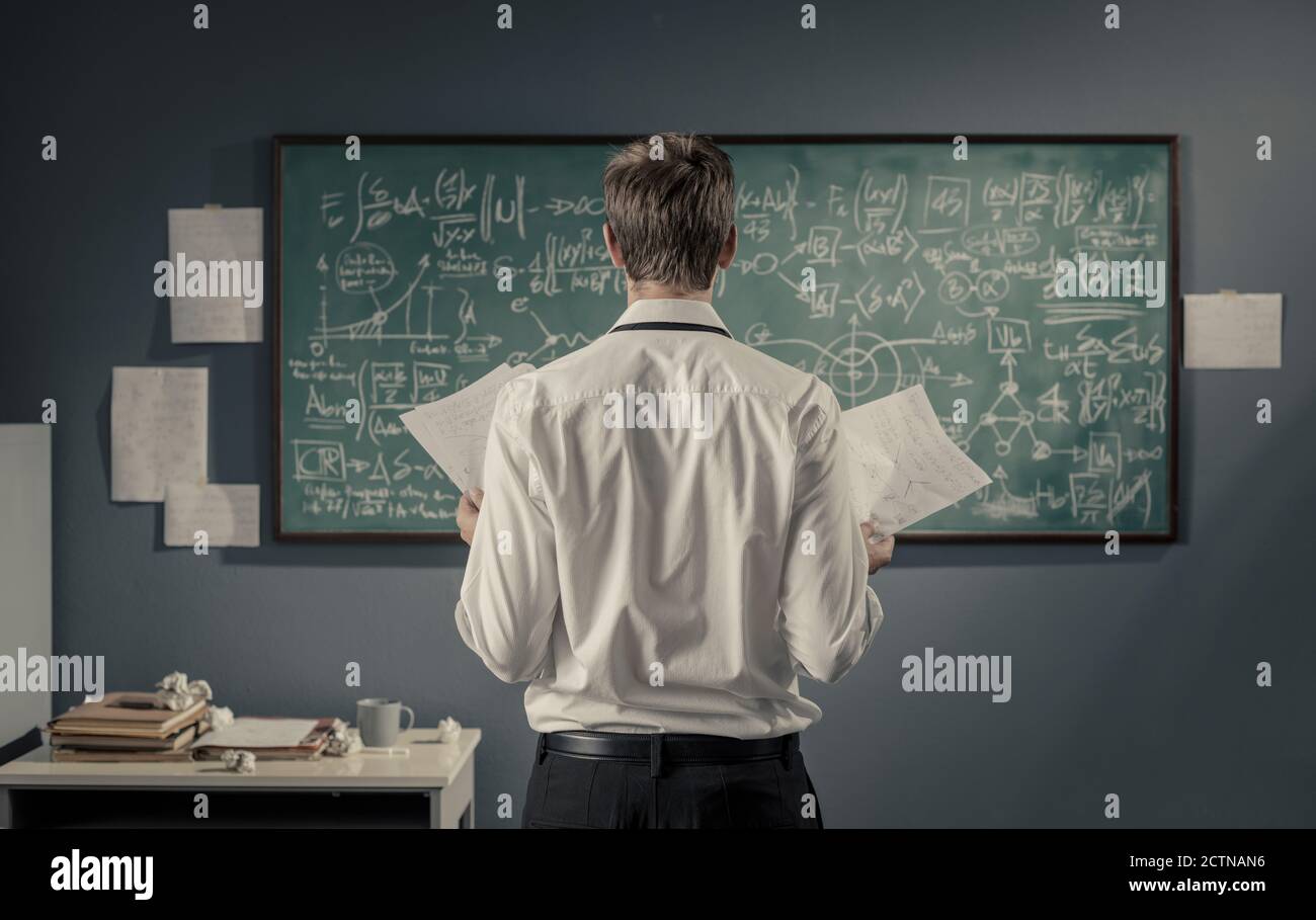 Young mathematician and researcher studying maths formulas on the ...