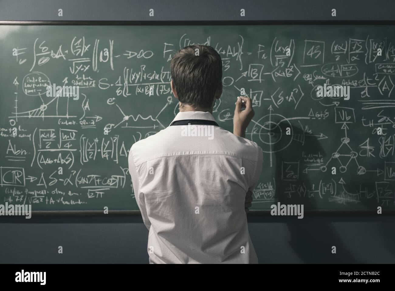 Young mathematician solving problems and writing formulas on the ...