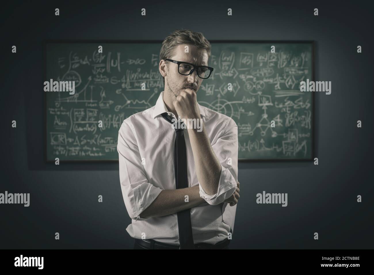 Brilliant mathematical researcher standing in front of a chalkboard ...