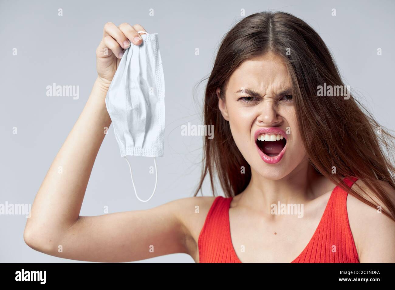 Woman with angry facial expression medical mask in hand open mouth ...