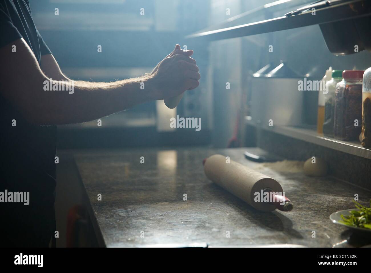 unrecognizable male chef shaping ball from soft dough while cooking ...