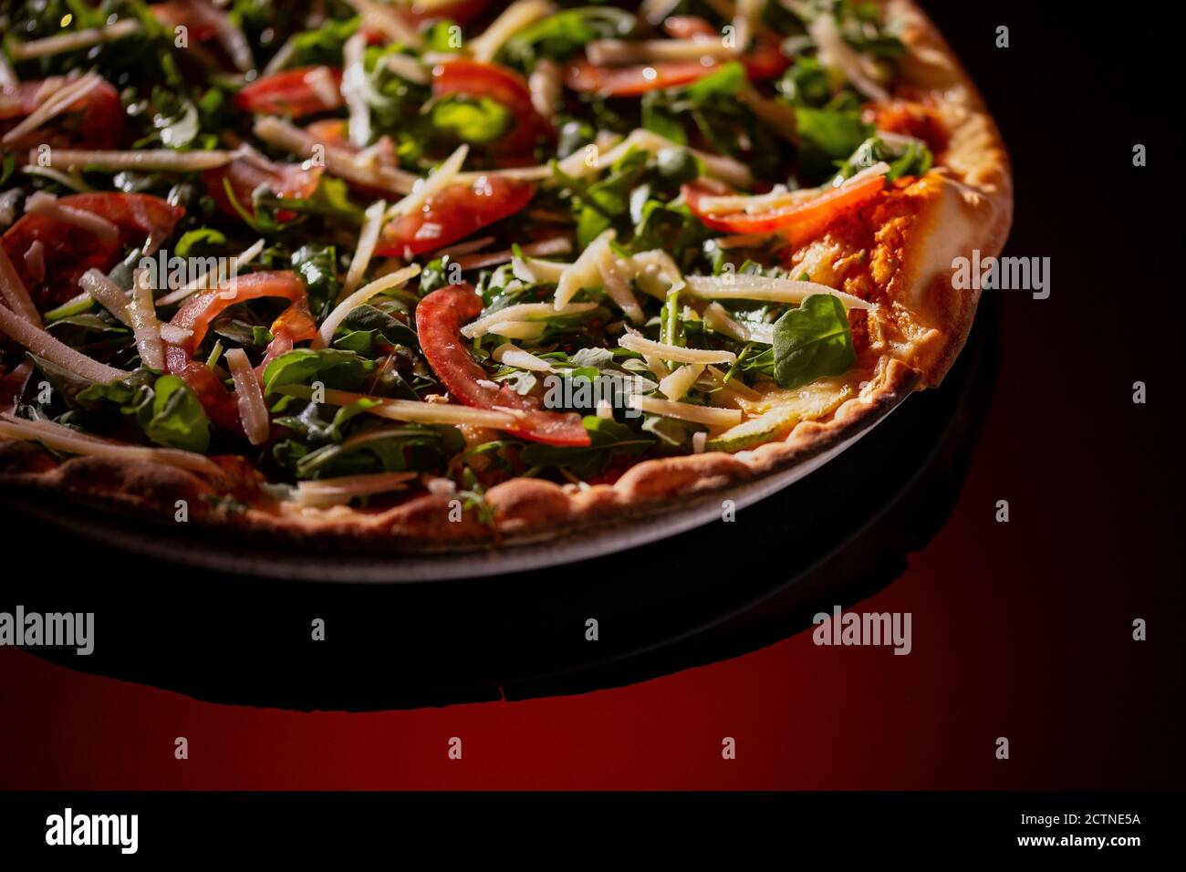 From above plate of tasty fresh pizza on dark red background Stock ...