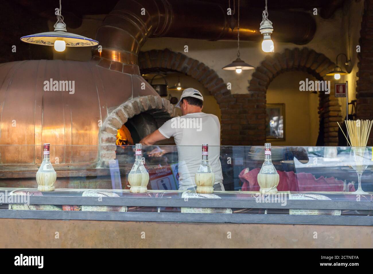 ROME, ITALY - 2014 AUGUST 17. Cook from behind making pizza in the ...