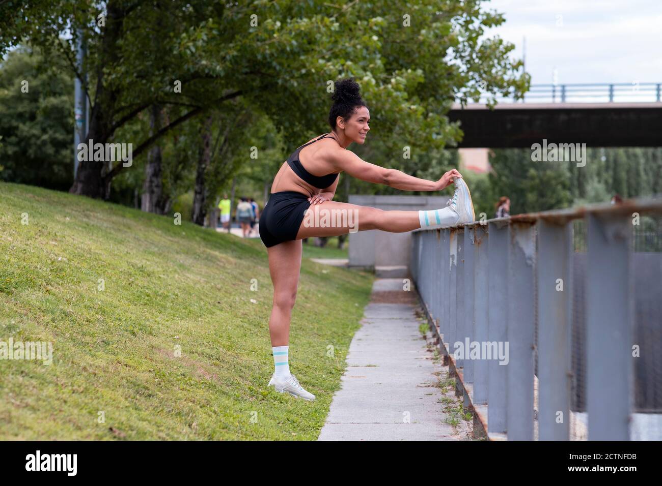 Side view of flexible African American female athlete standing near ...
