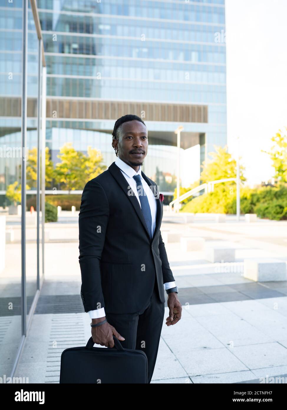 Serious African American male entrepreneur wearing elegant suit walking ...