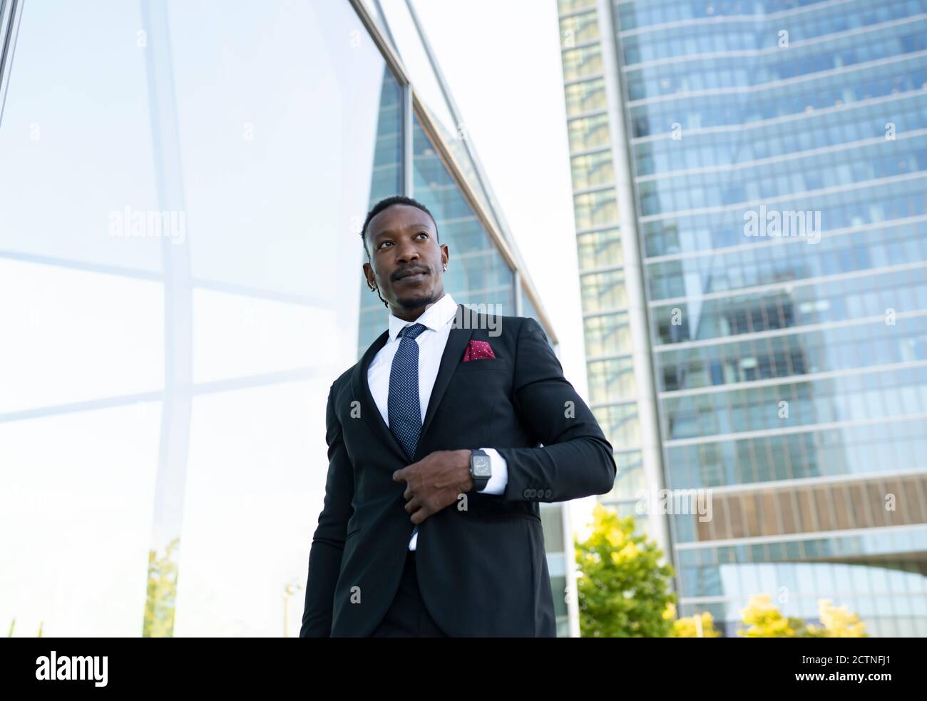 Serious African American male entrepreneur wearing elegant suit walking ...