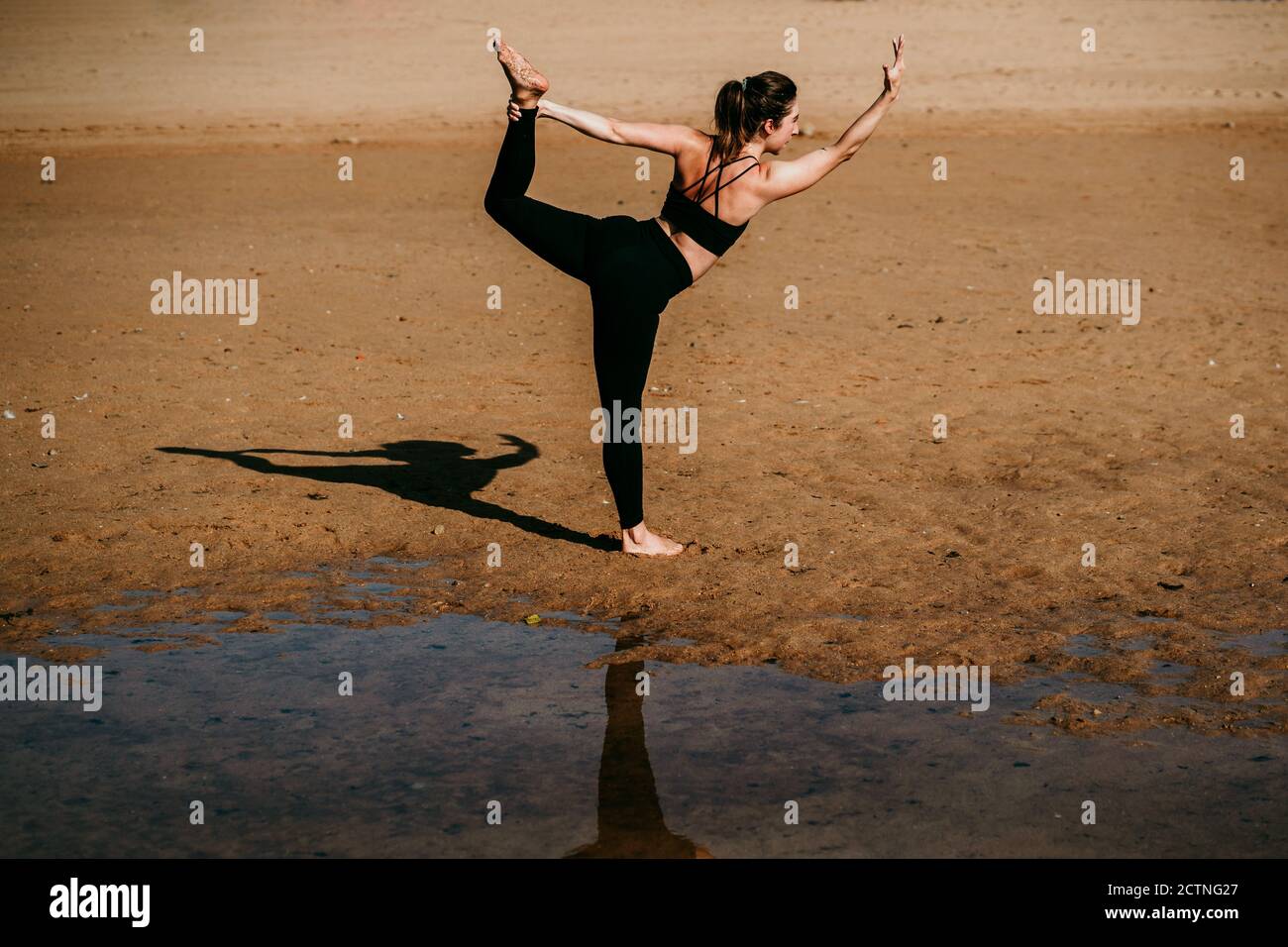 Side view of flexible unrecognizable female standing on sandy shore of ... Side view of flexible unrecognizable female standing on sandy shore of ...