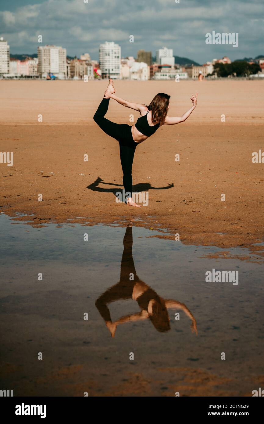 Side view of flexible unrecognizable female standing on sandy shore of ... Side view of flexible unrecognizable female standing on sandy shore of ...