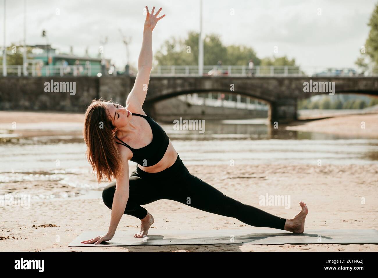 Tranquil female practicing yoga with closed eyes in Side Lunge with ...