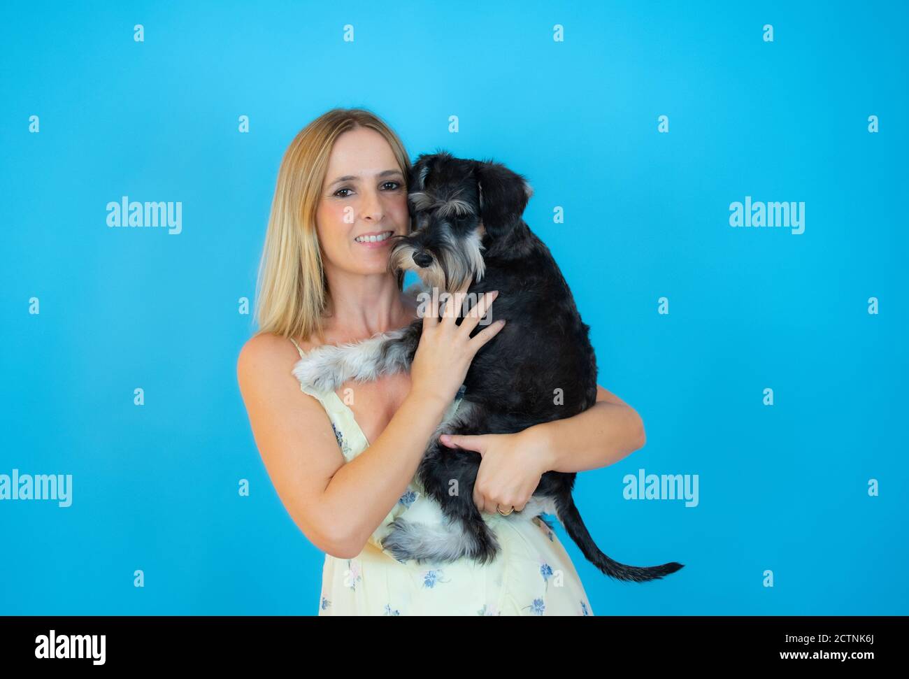Cute young woman hugs her puppy schnauzer dog. Love between owner and ...