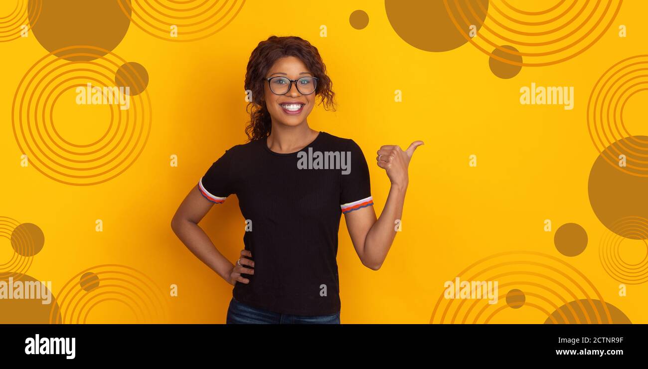 Pointing at side, smiling. African woman's portrait. Beautiful female ...