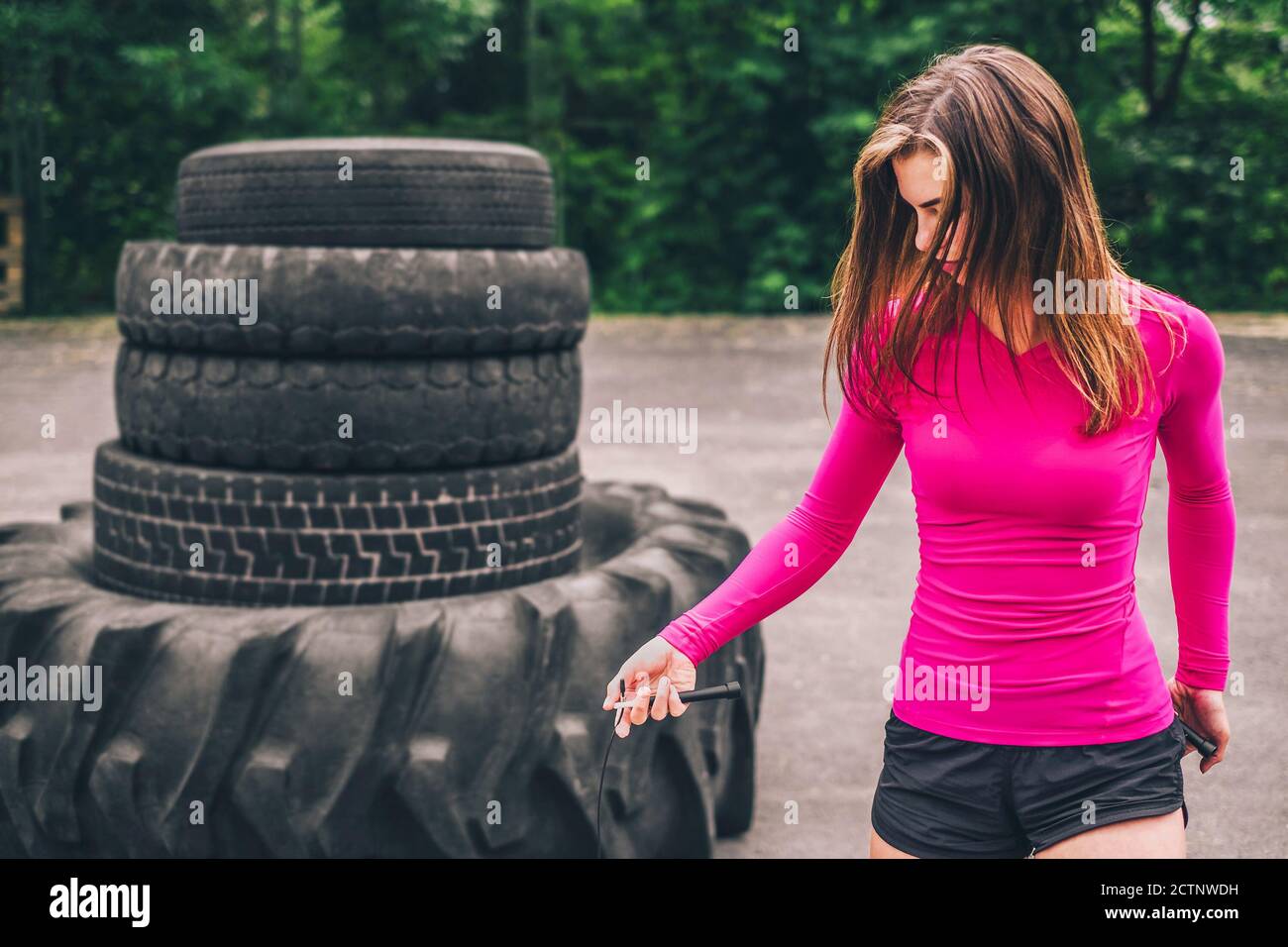 Pretty sporty girl with rope training outdoor Stock Photo - Alamy