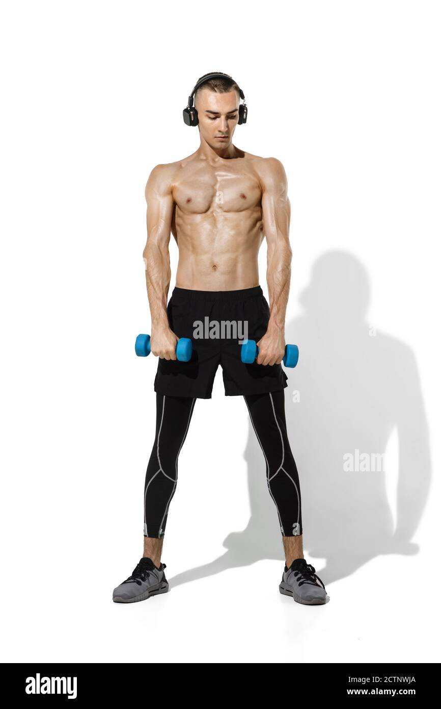 Weights. Stylish young male athlete practicing on white studio ...