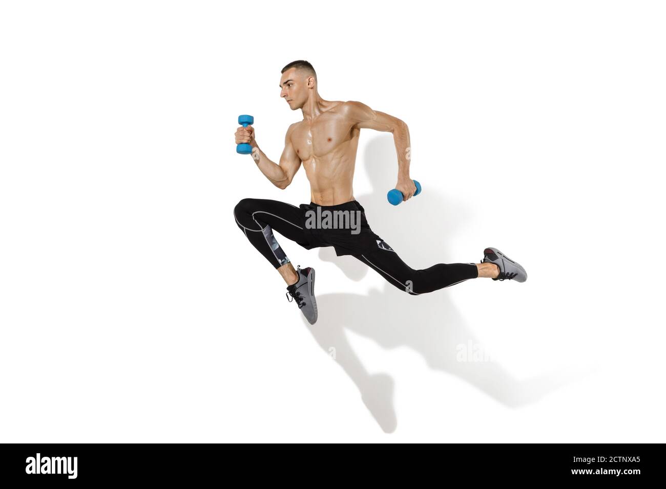 Running, jumping high. Stylish young male athlete on white studio ...