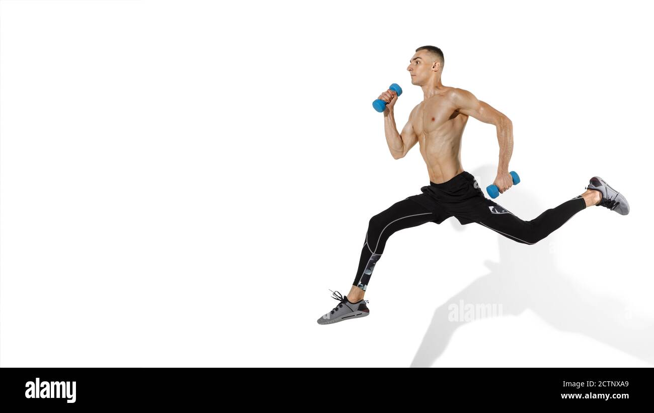 Running, jumping. Stylish young male athlete on white studio background ...