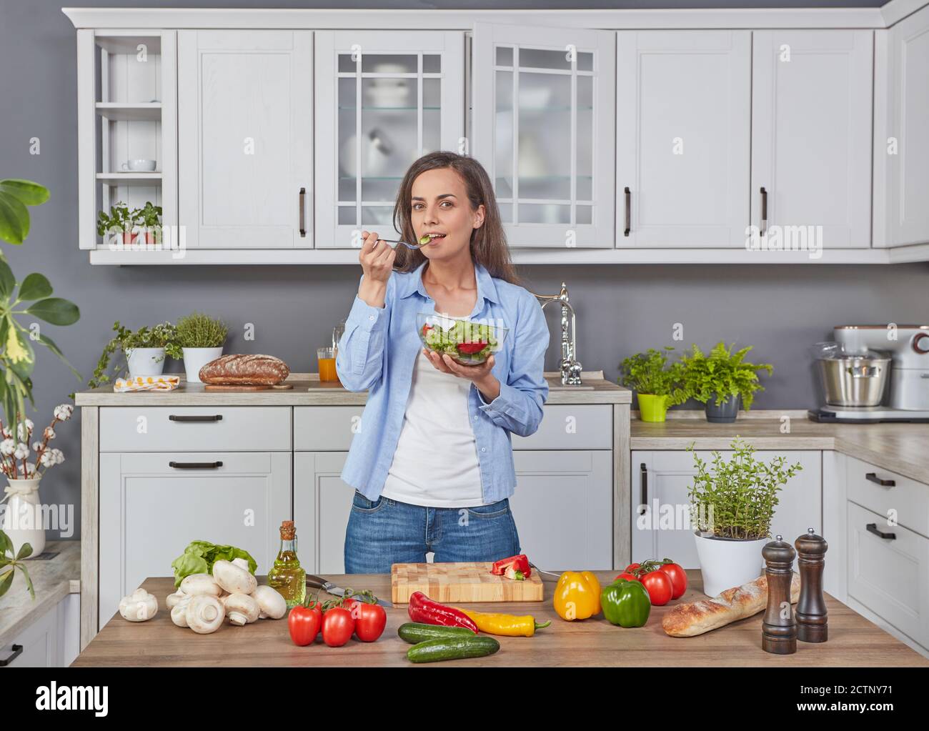 Cheerful young woman cooking Stock Photo - Alamy