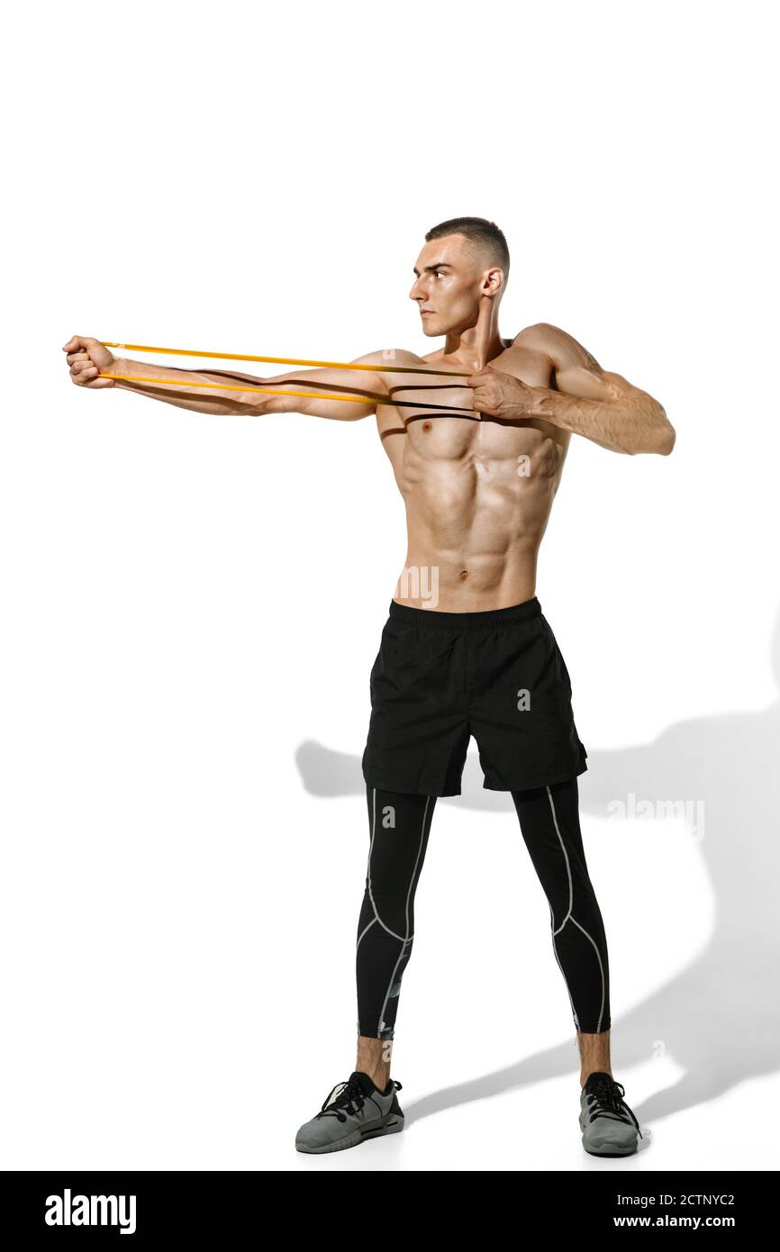 Confident, muscular stretching. Stylish young male athlete on white ...