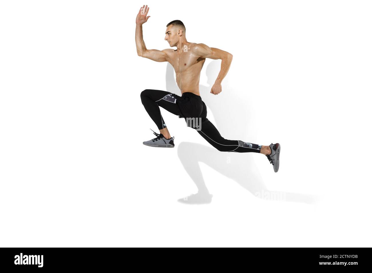 Running, jumping high. Stylish young male athlete on white studio ...