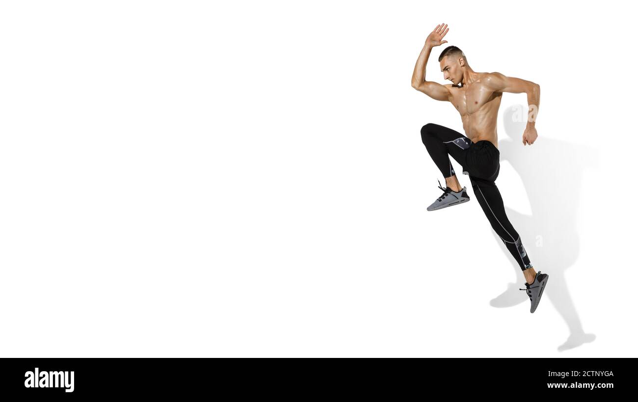 Running, jumping. Stylish young male athlete on white studio background ...