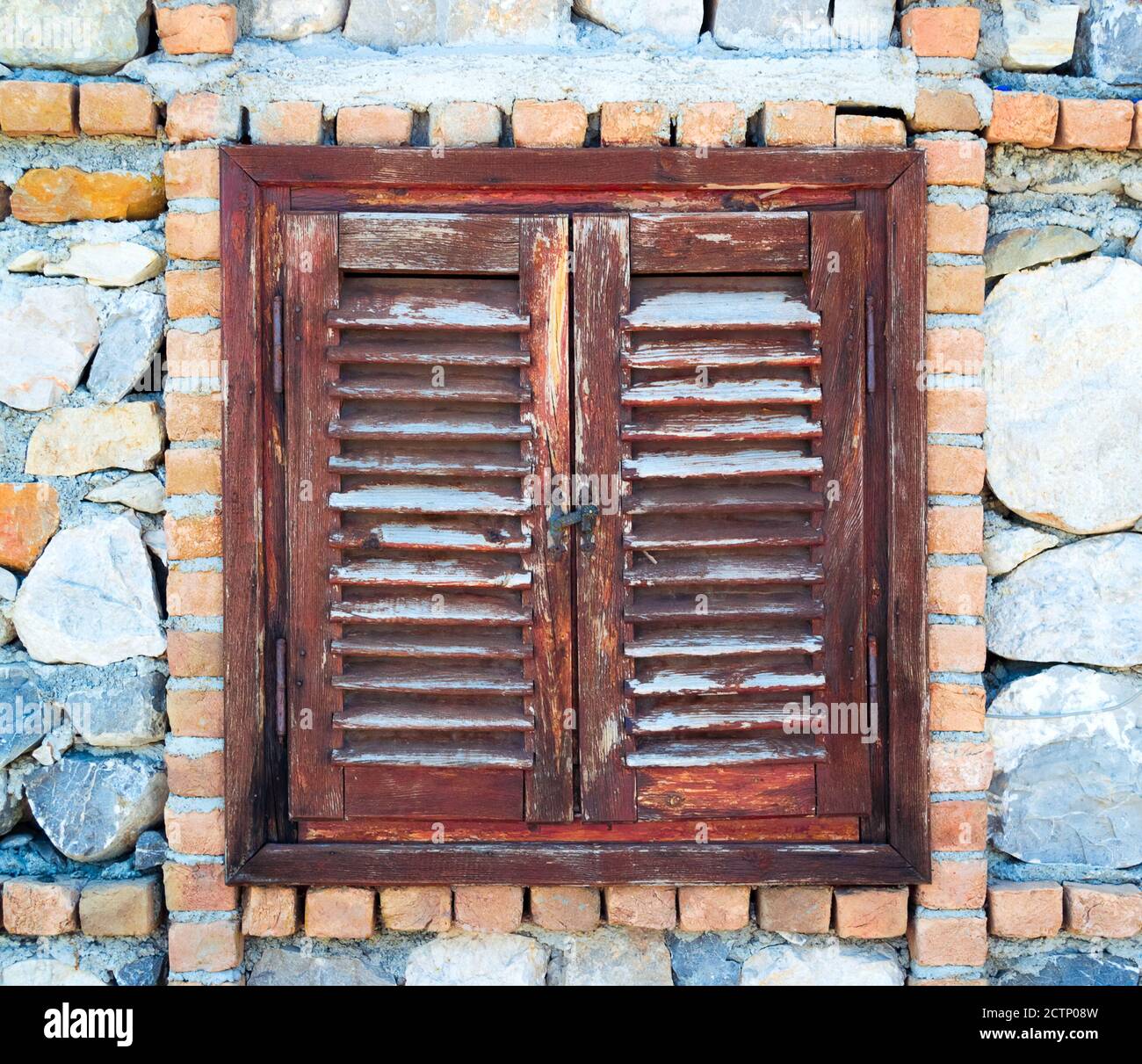 Old wooden mediterranean window shutters closed in the stone house ...