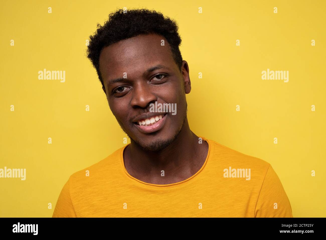 Smiling young african american man on yellow background Stock Photo - Alamy