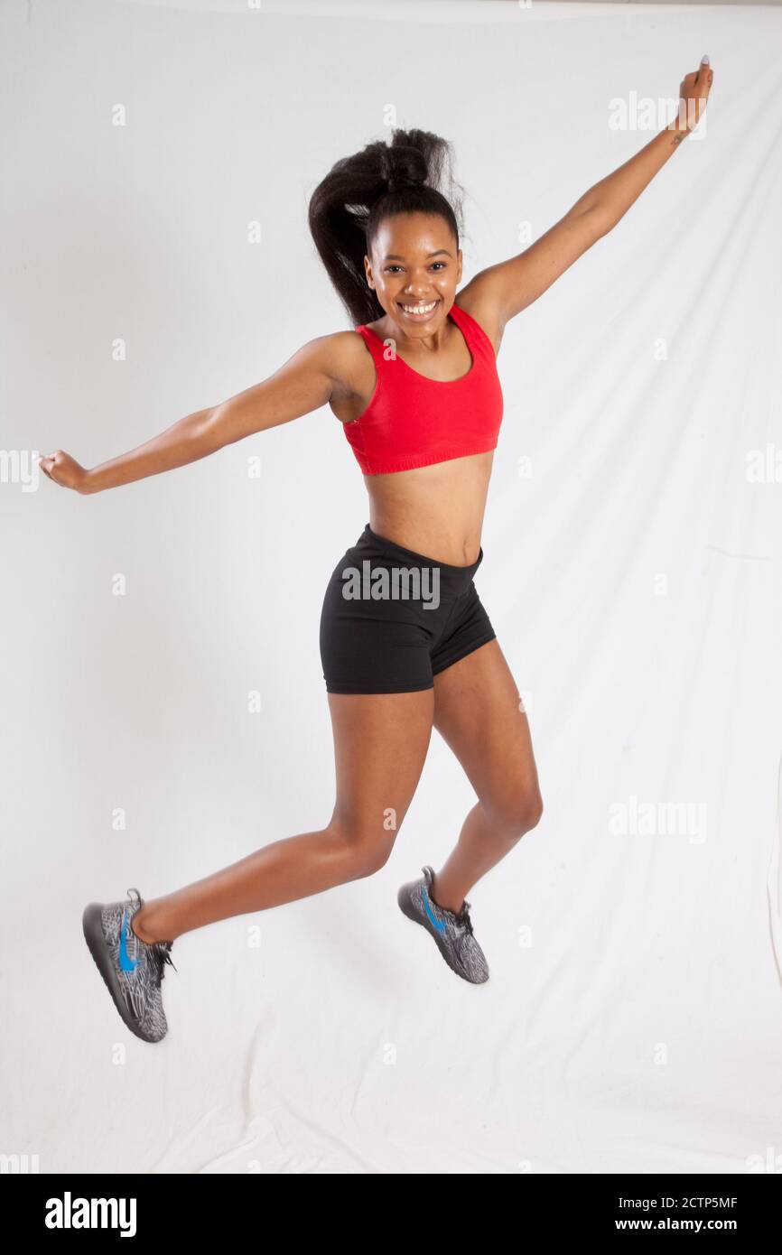Beautiful woman in exercise outfit jumping Stock Photo - Alamy