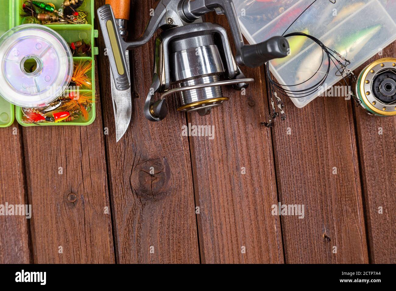 Different fishing tacles with lures and reels on wooden brown ...
