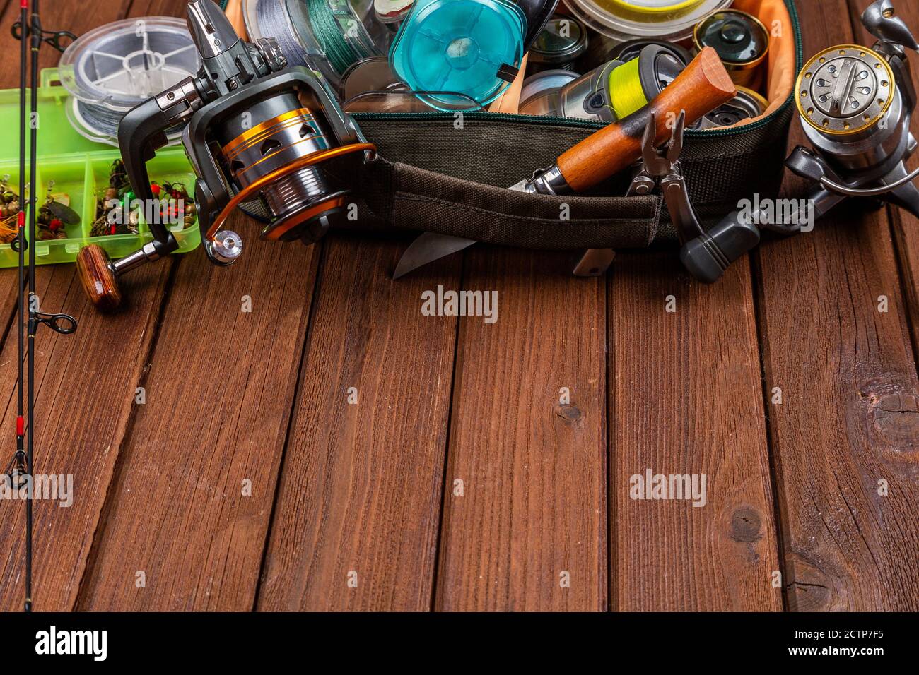 Different fishing tacles with lures and reels on wooden brown ...