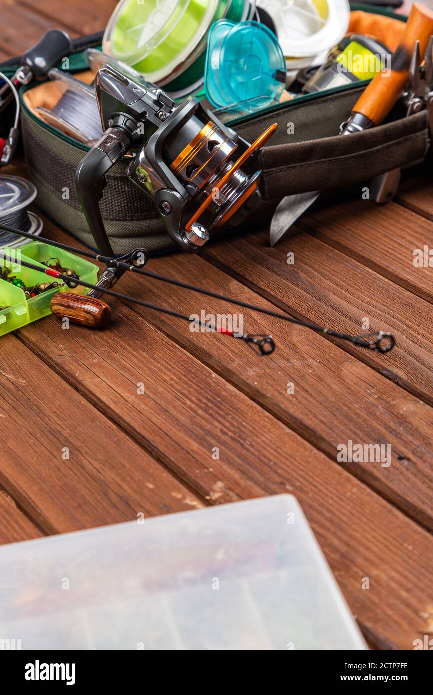 Different fishing tacles with lures and reels on wooden brown ...