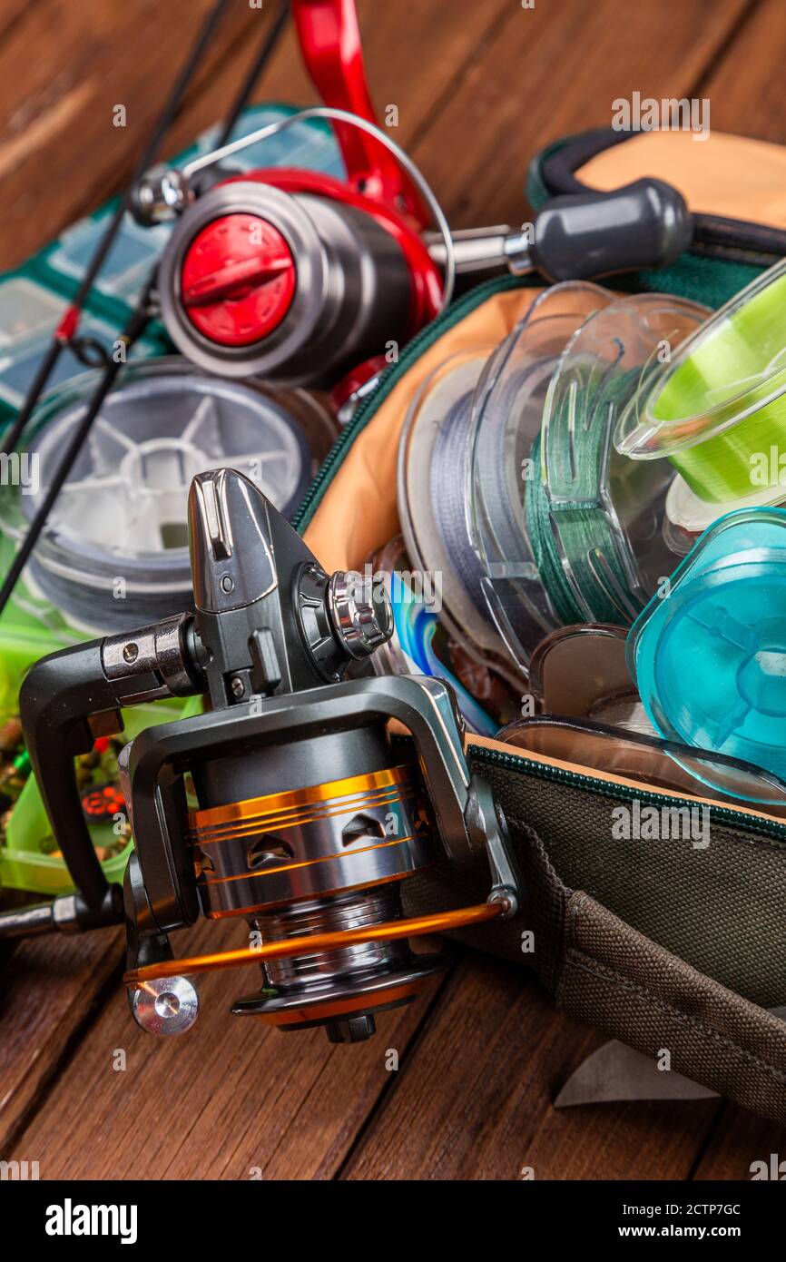 Different fishing tacles with lures and reels on wooden brown ...