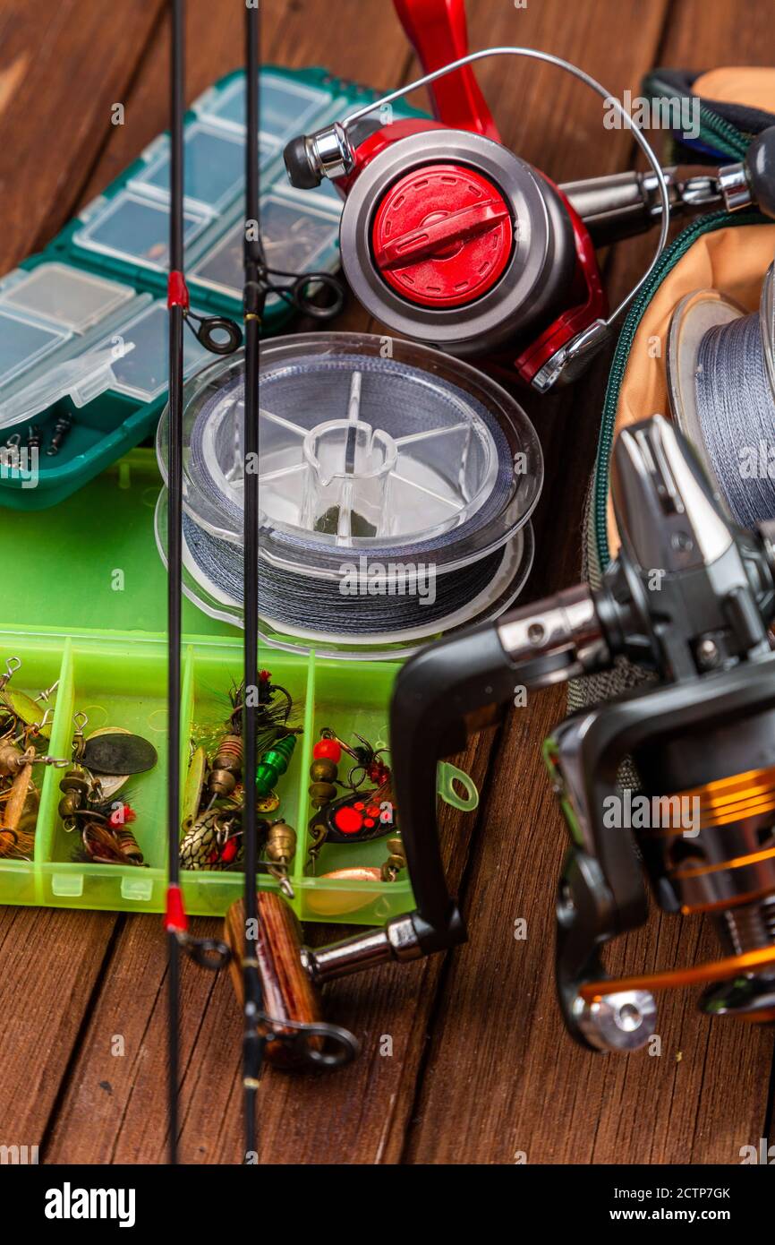 Different fishing tacles with lures and reels on wooden brown ...