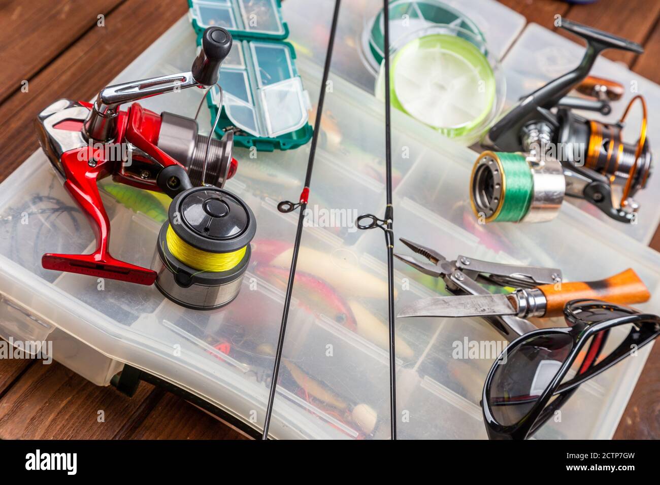 Different fishing tacles with lures and reels on wooden brown ...