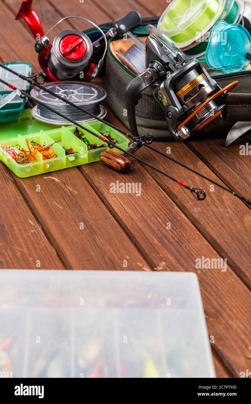 Different fishing tacles with lures and reels on wooden brown ...