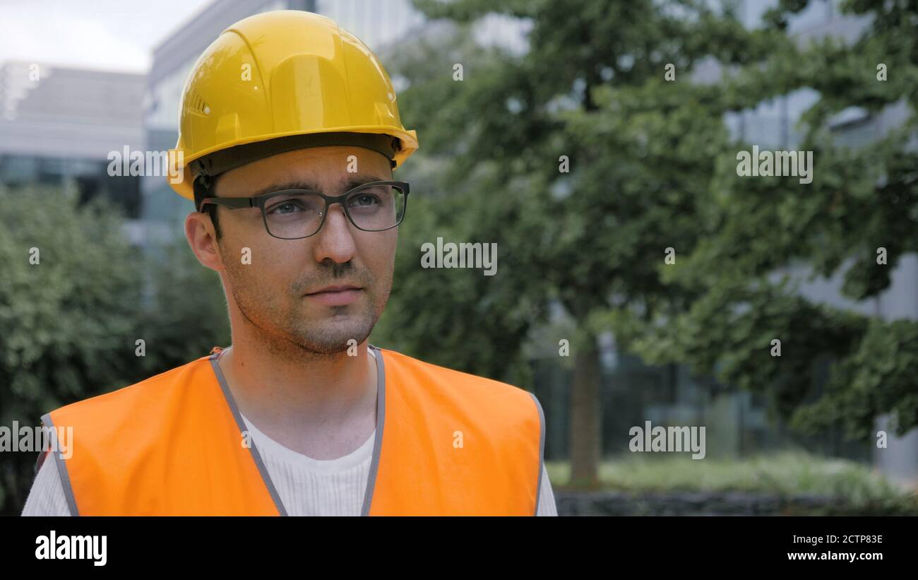 Construction worker in hard hat and glasses walking Stock Photo - Alamy